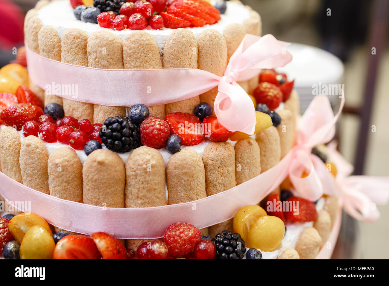 Le gâteau aux fruits rouges. Mariée et le marié couper gâteau sucré sur ...