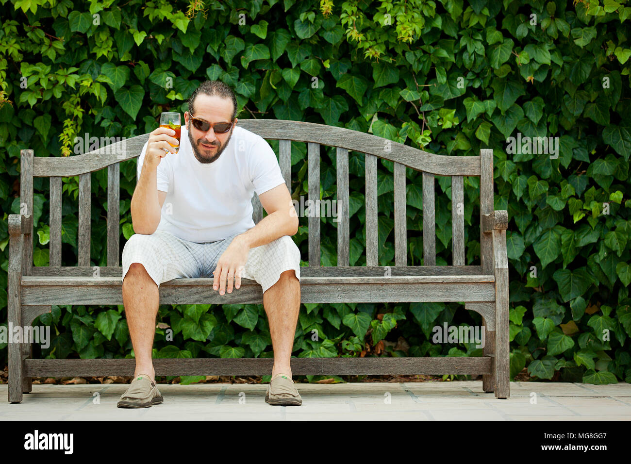 Homme Assis Sur Un Banc Relaxant Banque De Photographies Et Dimages à