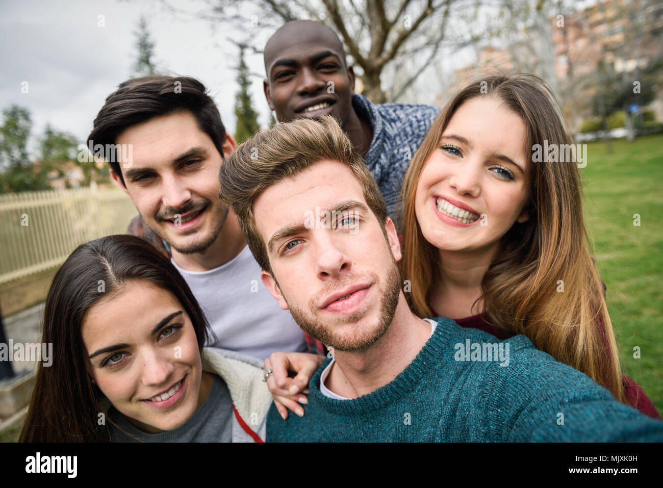 Groupe Multiracial Damis En Tenant Dans Un Parc Urbain Selfies Banque