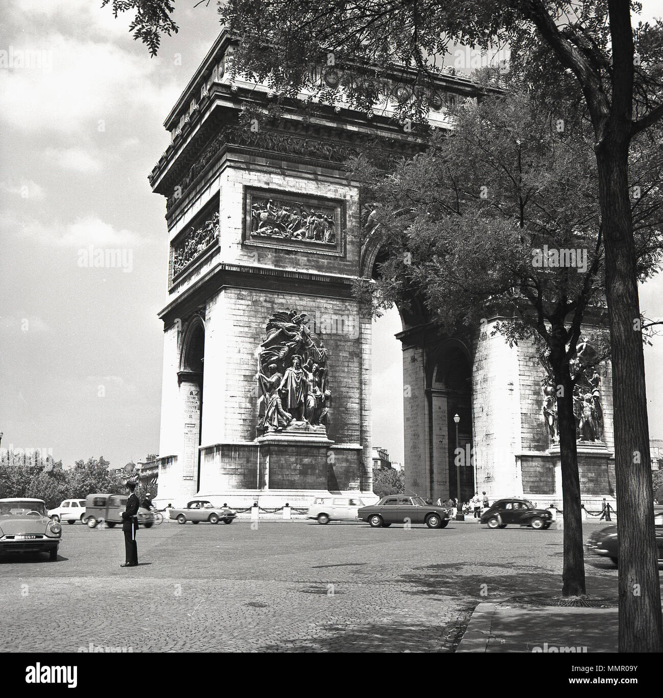 Dans les années 1950, les véhicules automobiles contournent le monument emblématique de l'Arc de ...