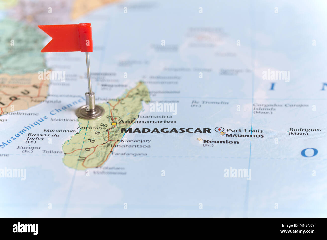 Petit drapeau rouge marquant Madagascar sur une carte du monde Photo ...