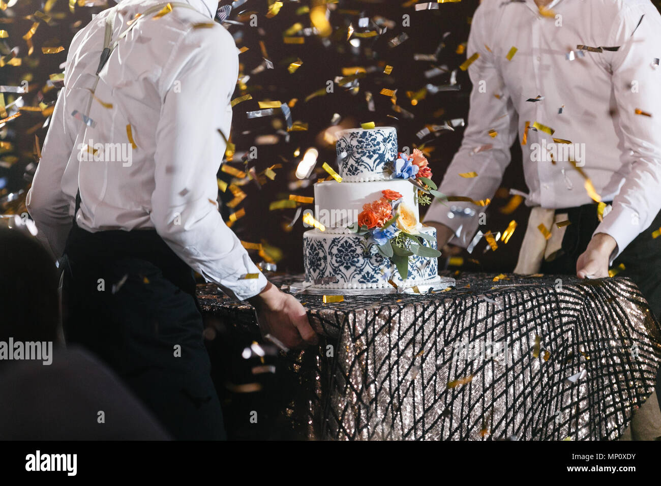 Waiter présentera au restaurant. Gâteau de mariage avec des fleurs ...