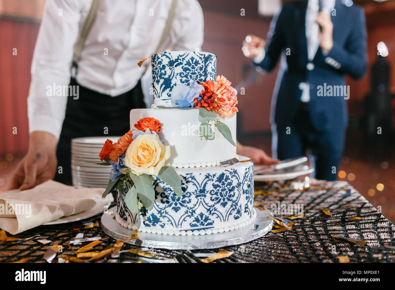 Waiter présentera au restaurant. Gâteau de mariage avec des fleurs ...