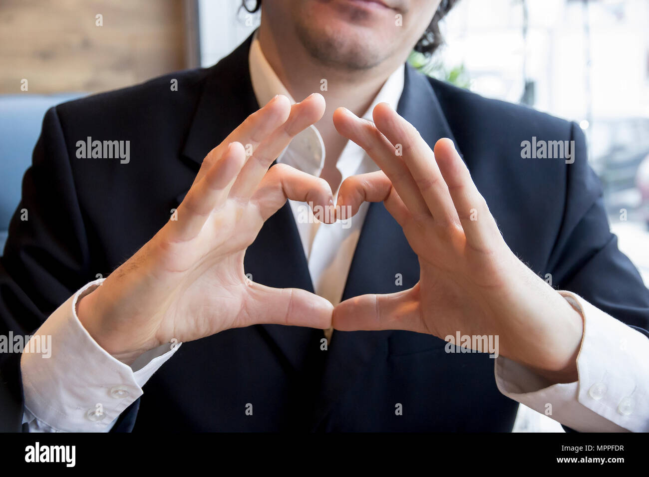 Jeune homme en costume dans l'entreprise cafe showing Thumbs up hand ...