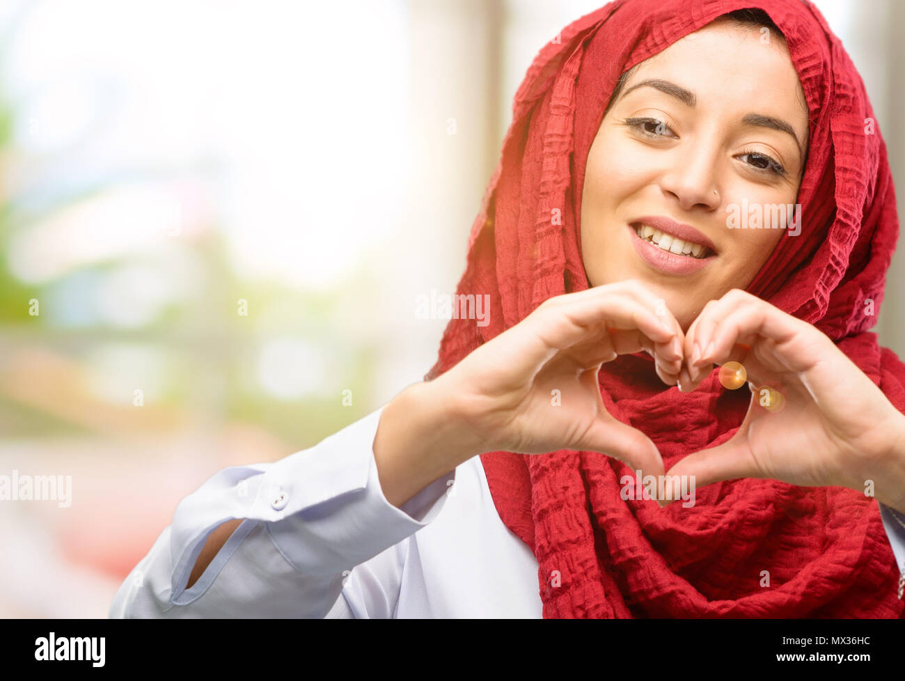 Jeune femme arabe portant le hijab professionnels montrant l'amour avec ...