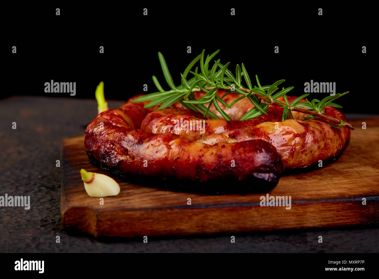 Spirale grillé ou rôti saucisses de porc au romarin, sel et poivre sur planche à découper en ...