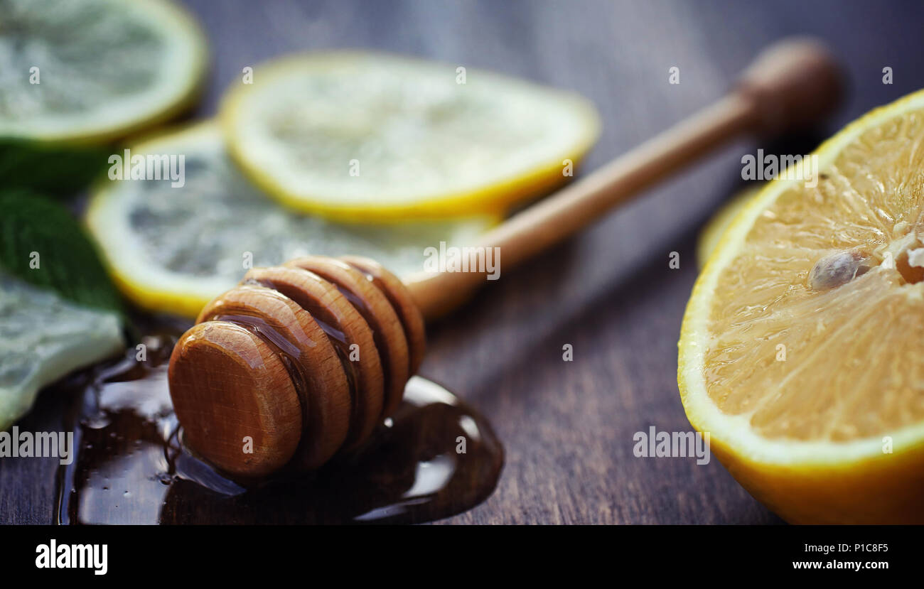 Miel et citron. Stick miel et tranches de tranches de citron sur la ...