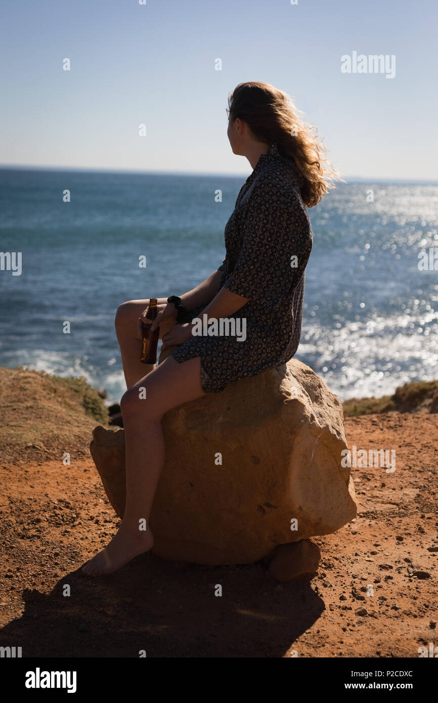 Femme assise seule sur une plage Banque de photographies et d’images à haute résolution - Alamy