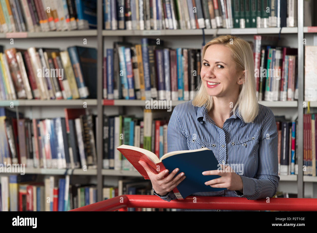 Dans la bibliothèque - Jolie Étudiante avec des livres qui travaillent dans une école ...