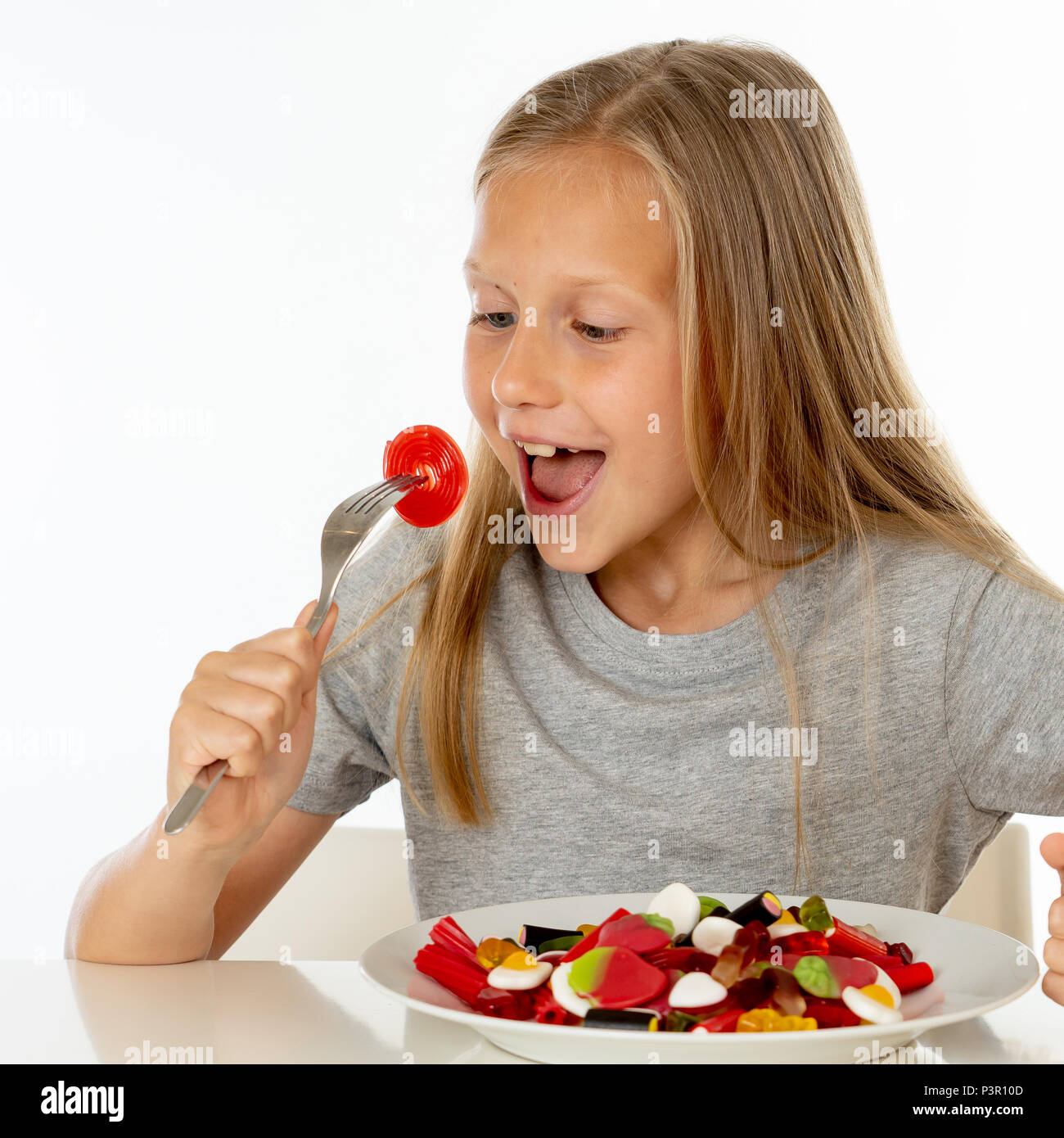 Funny happy girl avec la plaque de bonbons sucette lollies happy little girl eating big sugar candy lollies kid manger des sucreries. surpris enfant avec des bonbons. iso Photo Stock Alamy