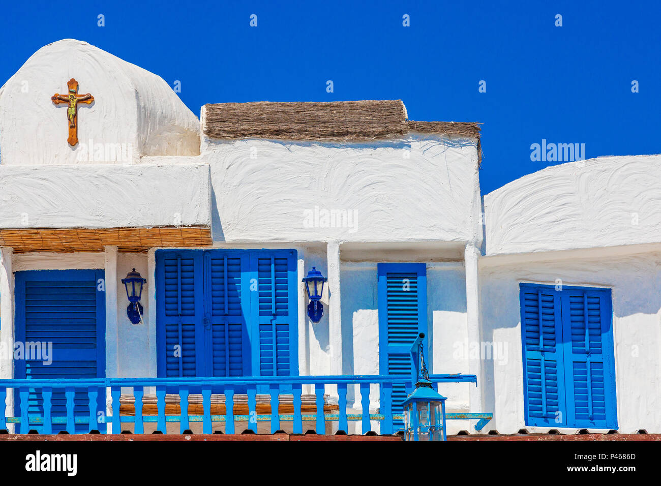 Maison de style grec traditionnel, avec des volets bleus et croix ...