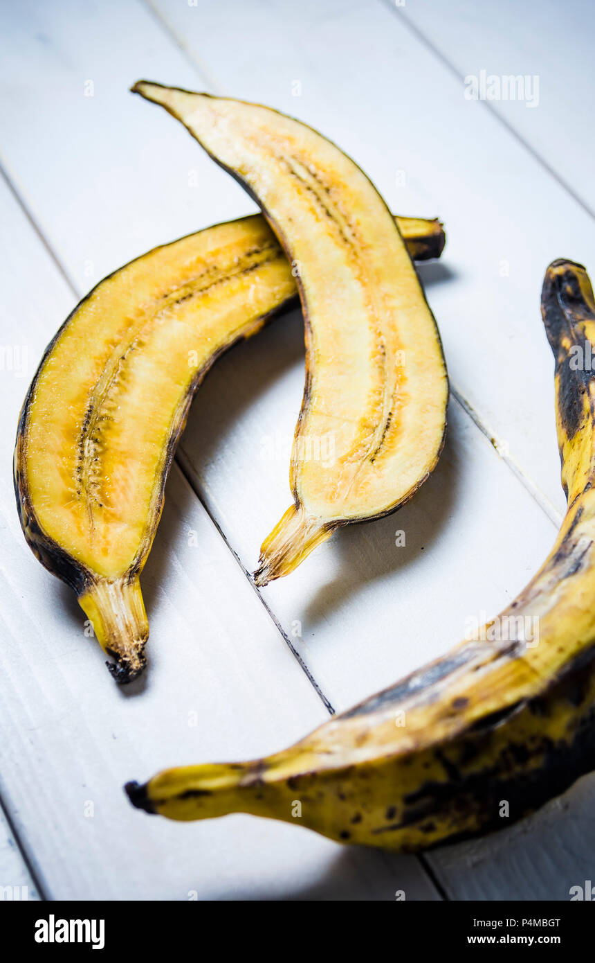 La banane plantain coupée en deux et ensemble on a white background ...