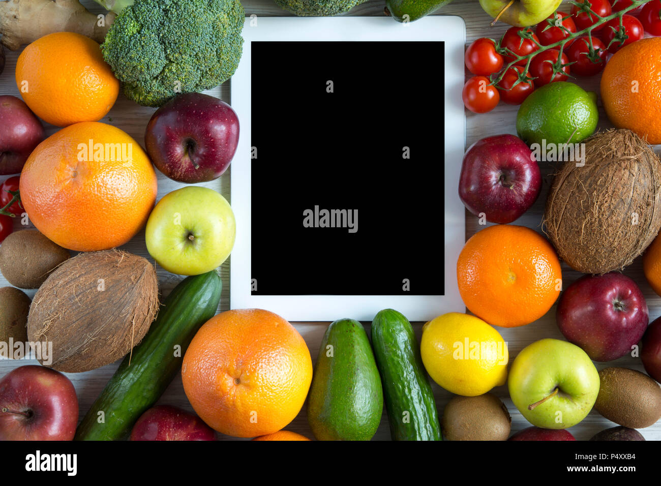Tablette avec écran noir. Les fruits et légumes frais biologiques sur ...