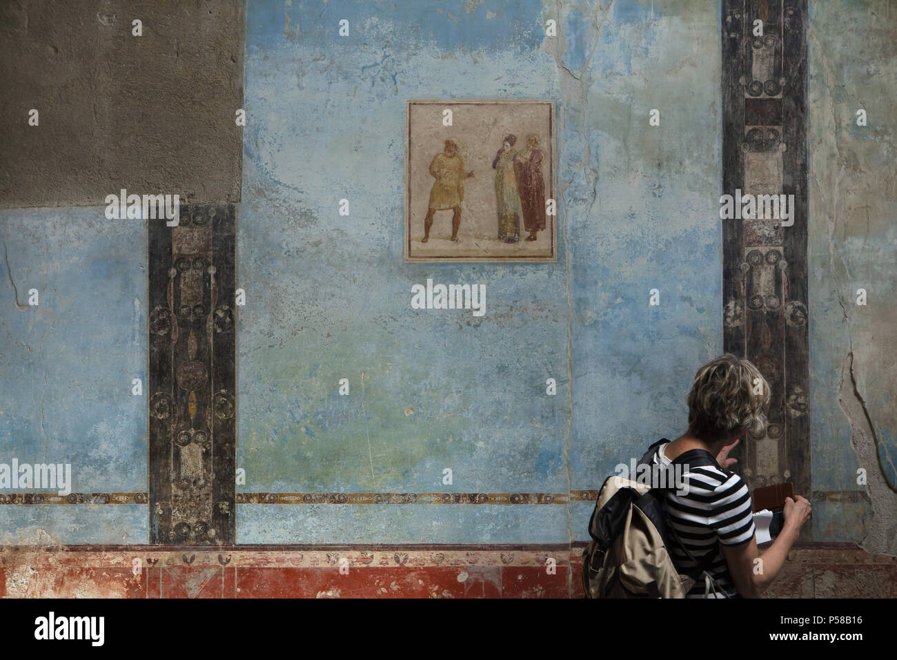 Visiteur en face de la fresque de la troisième scène théâtrale avec ...