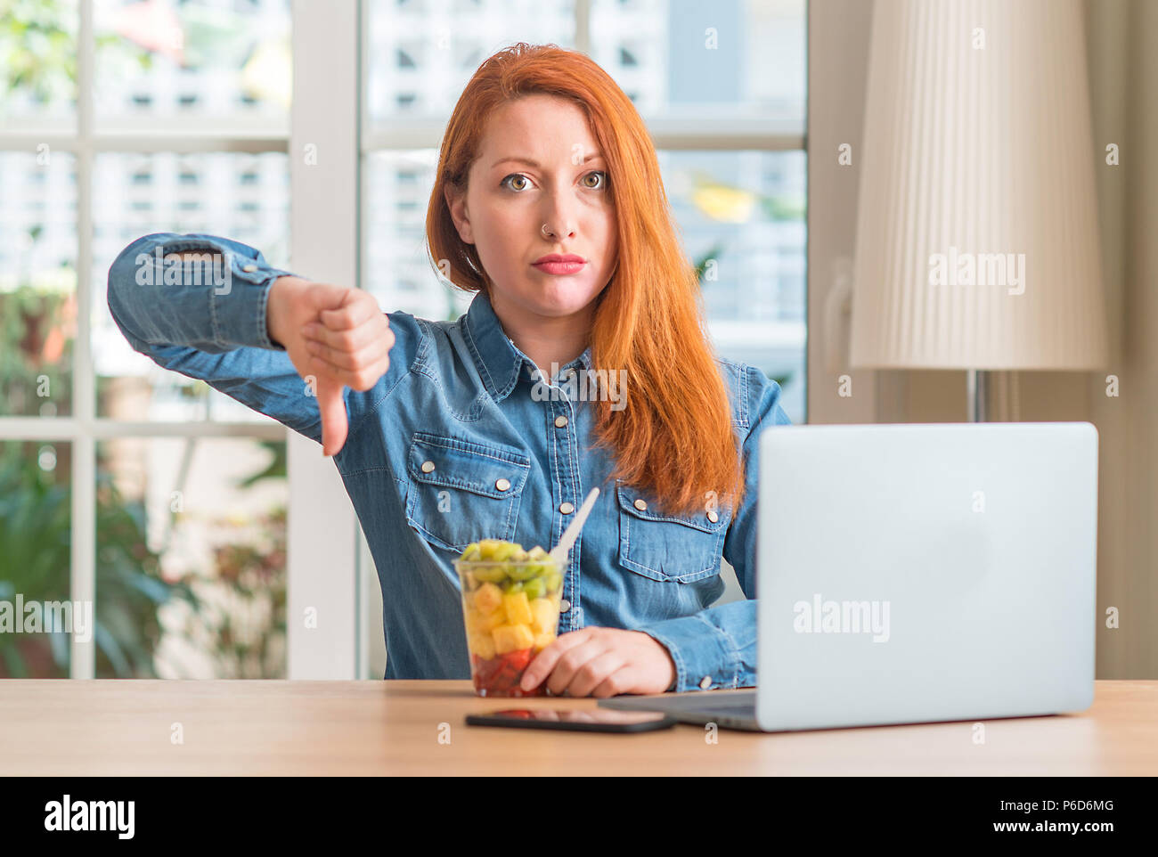 Femme rousse à l'aide d'un ordinateur portable à la maison avec la ...