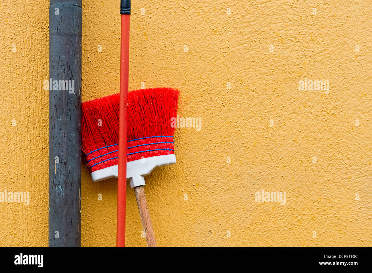 Balai rouge contre le mur jaune Burano Italie Photo Stock - Alamy