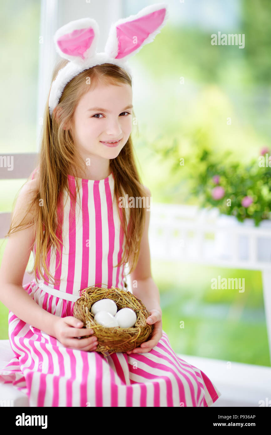 Cute little girl wearing Bunny Ears jouant sur la chasse aux œufs de ...