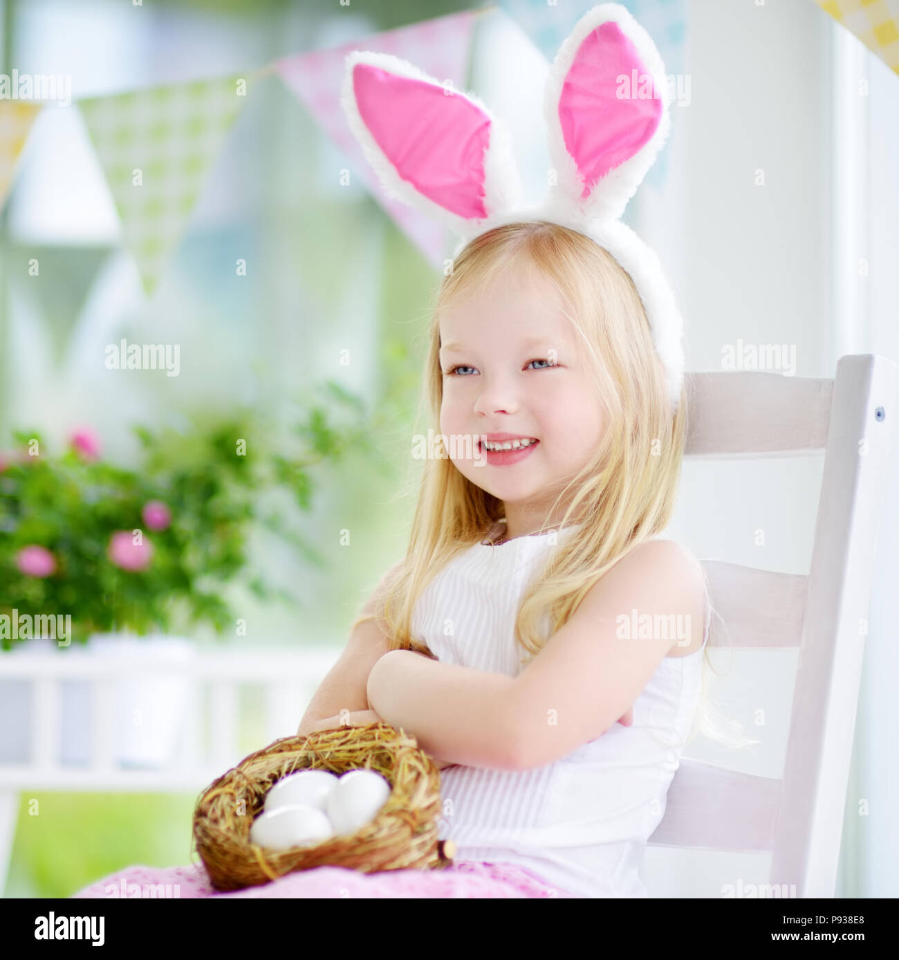 Cute little girl wearing Bunny Ears jouant sur la chasse aux œufs de ...