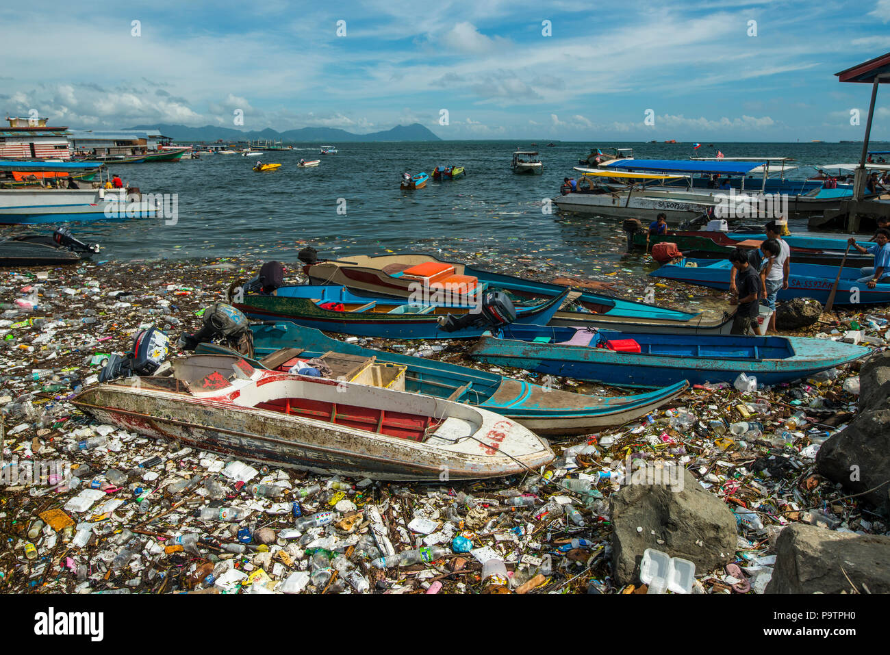 La pollution en plastique à côté de petits bateaux flottants au bord de ...