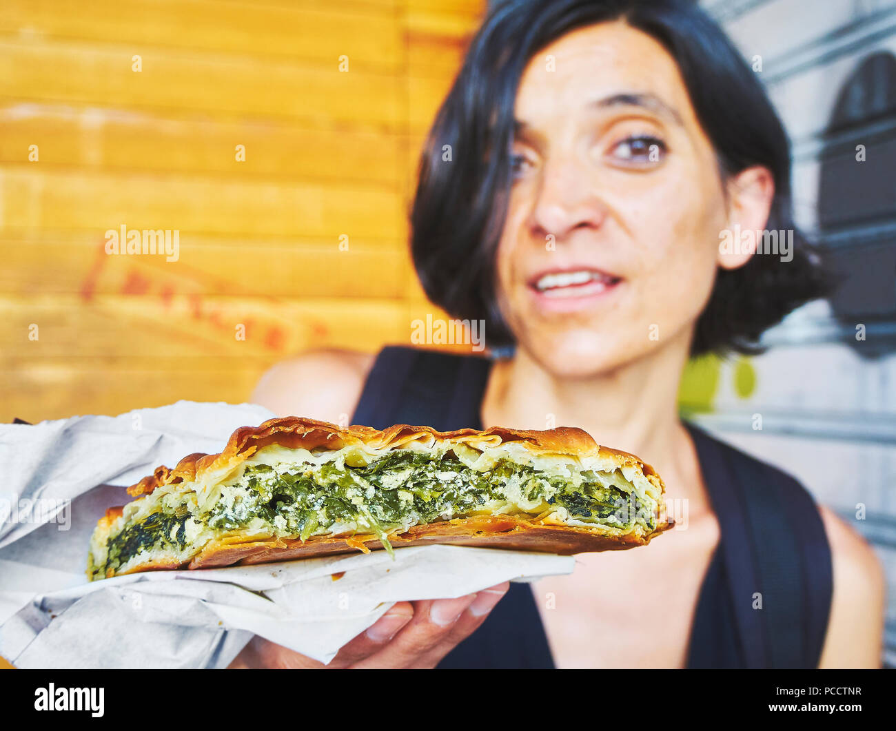 Femme grecque de manger un Spanakotiropita traditionnel, épinards et ...