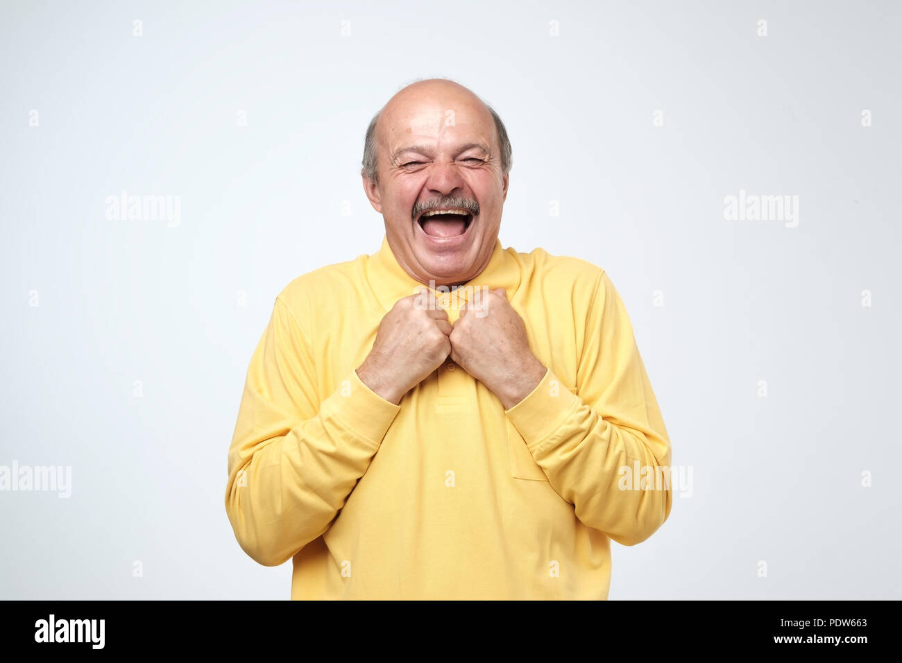L'adulte l'homme en jaune tshirt avec moustache de rire en regardant l ...