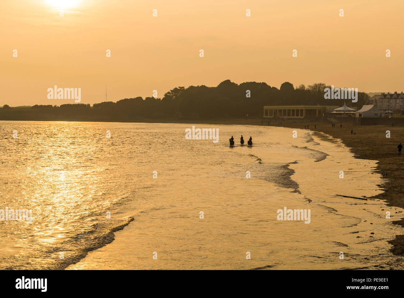 Groupe d'amis à cheval dans la mer à l'île de Barry, Vale of Glamorgan ...
