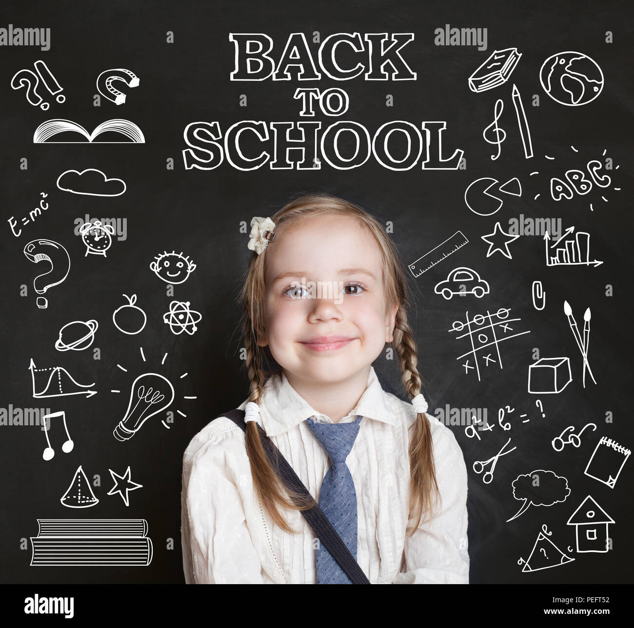 Heureux élève petite fille en classe à l'arrière-plan et tableau noir ...
