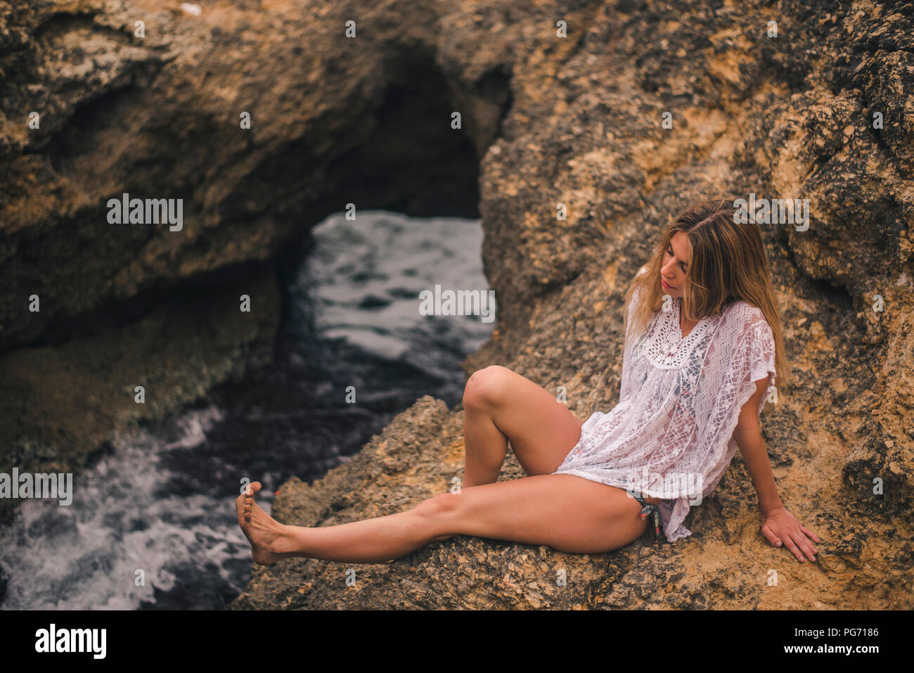 Les jeunes sont assis sur un rocher Banque de photographies et d’images à haute résolution - Alamy