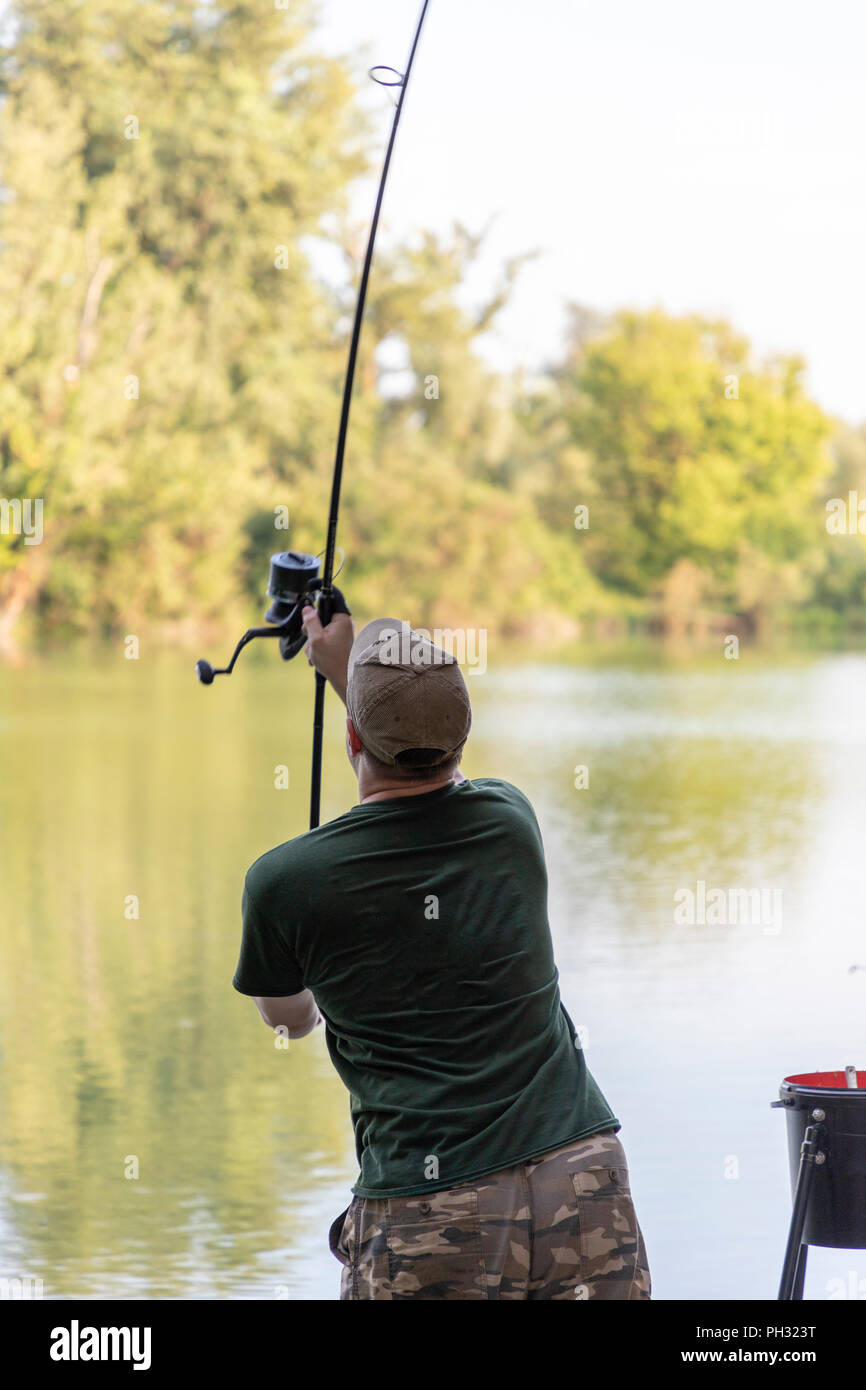 Pêcheur sur une action de pêche de la carpe dans le lac Photo Stock - Alamy