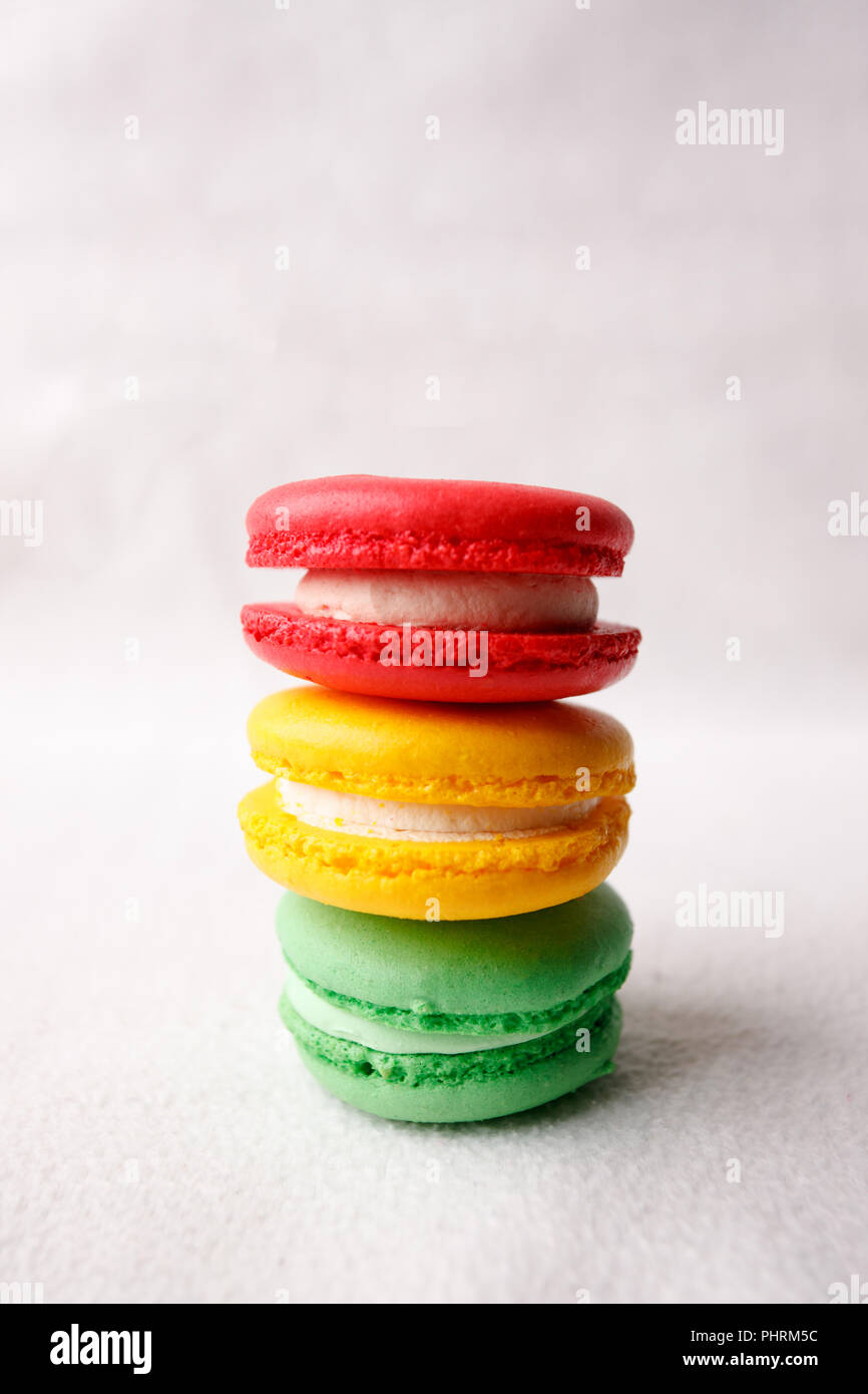 Différents types de macarons dans la pile sur fond blanc, feu doux ...