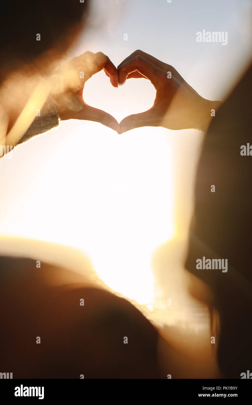 Vue arrière du couple in love gesturing coeur avec les doigts. Portrait ...