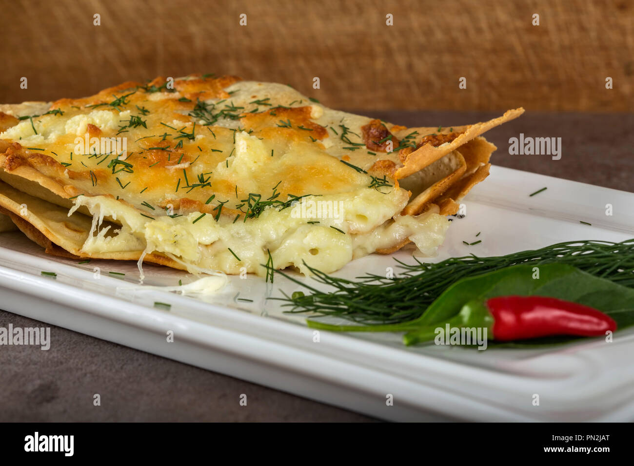 Crêpe au four farcies au jambon et crème chease, sur la plaque blanche ...