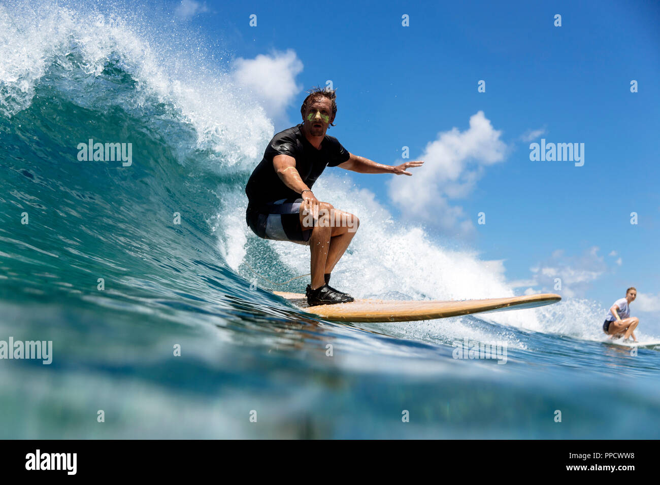L'homme et la jeune femme surf sur vague éclaboussant, homme, Maldives ...