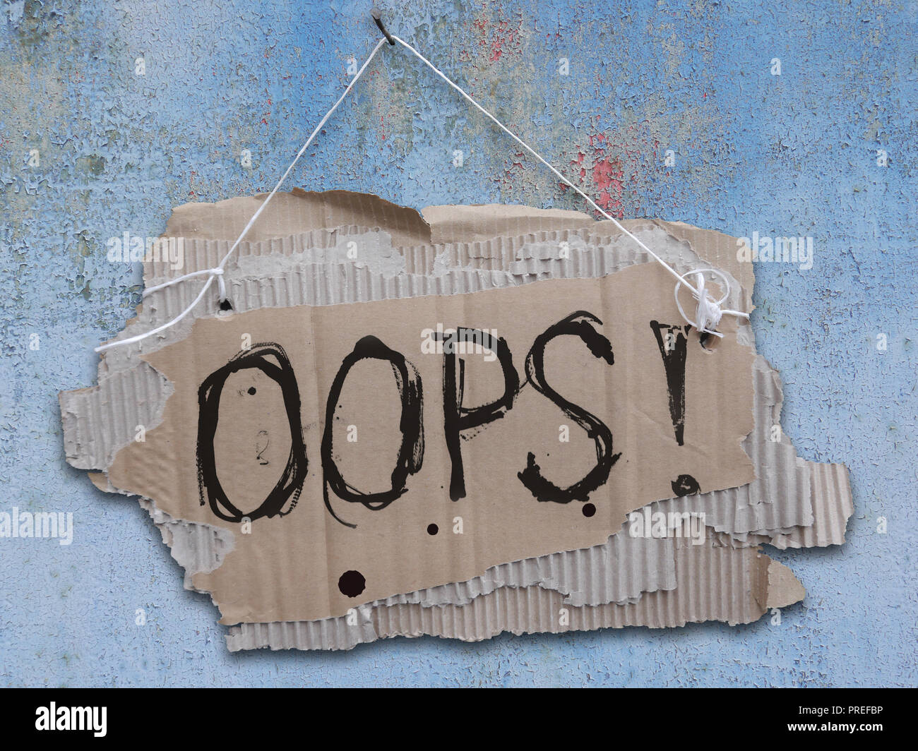 Signe de carton sur un cordon avec un mots OOPS. Déchiré, carton ondulé ...