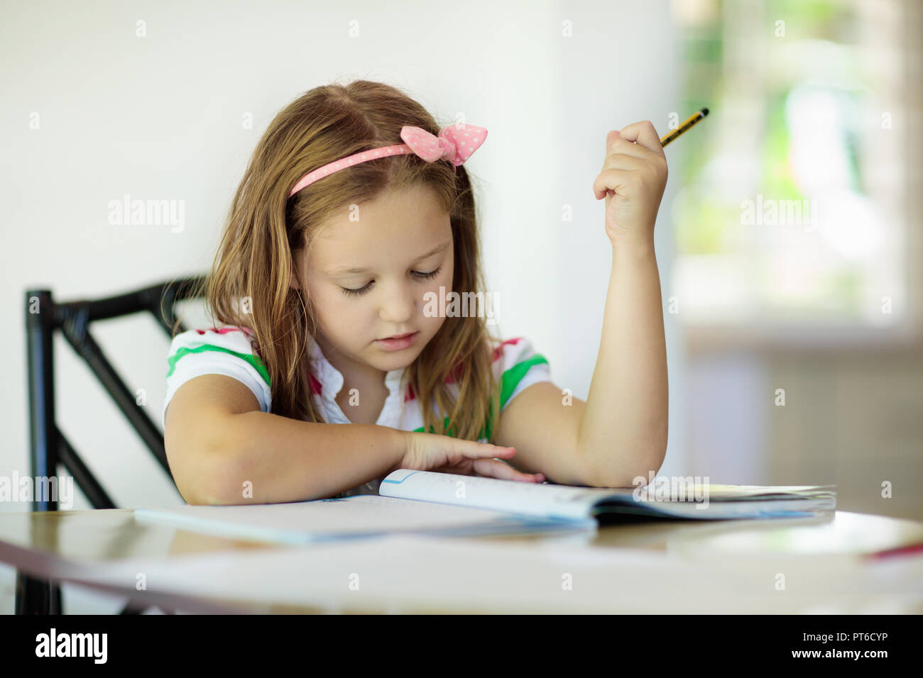 Cute little girl doing homework, livre de lecture, des pages à colorier ...