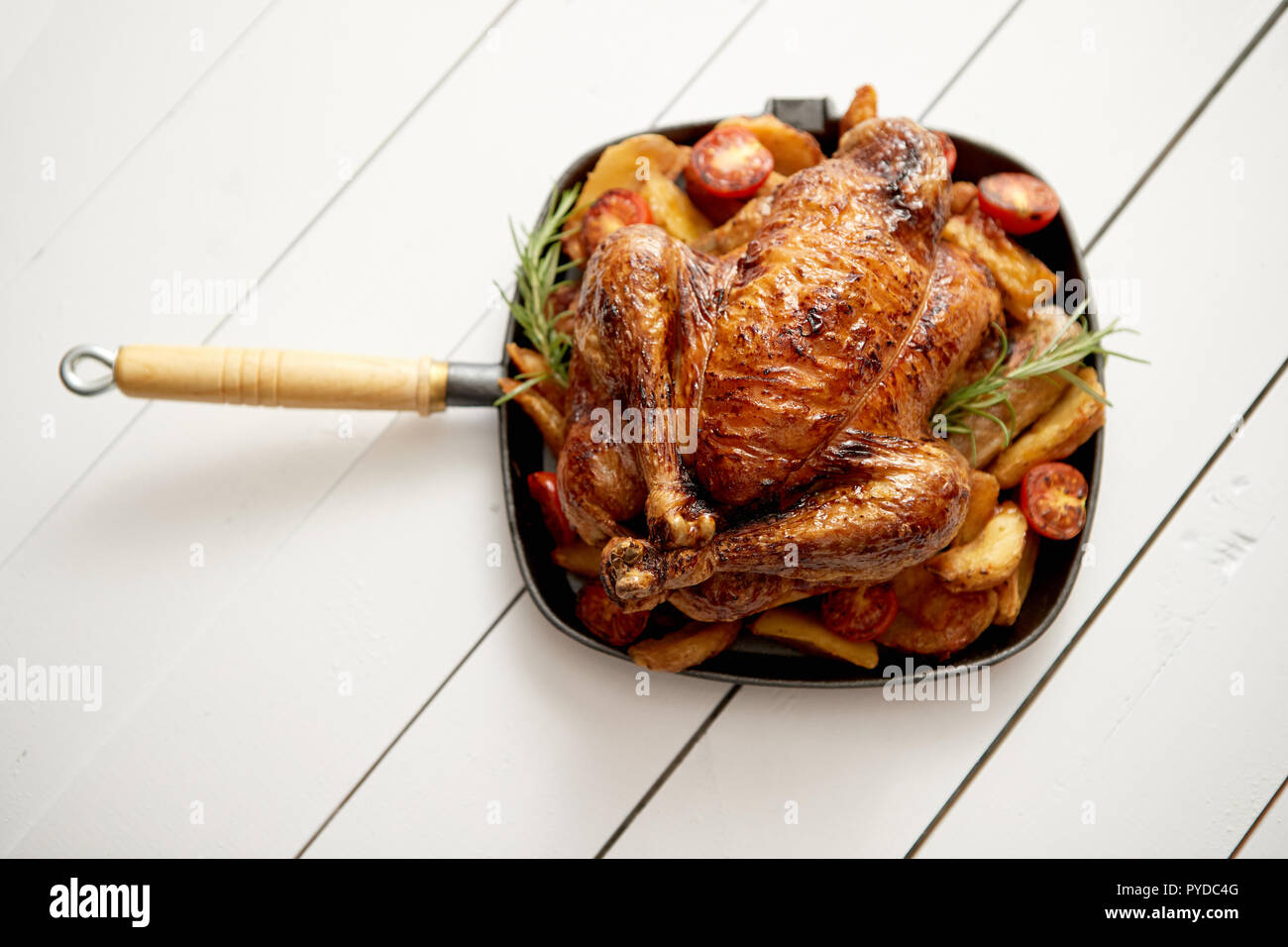 Poulet entier rôti en fonte pan noir. Avec des pommes de terre, tomates ...