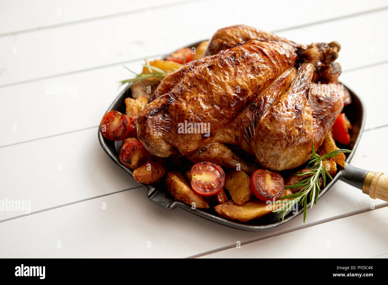 Poulet entier rôti en fonte pan noir. Avec des pommes de terre, tomates ...