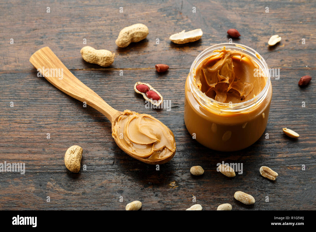 La pâte d'arachide dans un pot ouvert et d'arachides dans le peel ...