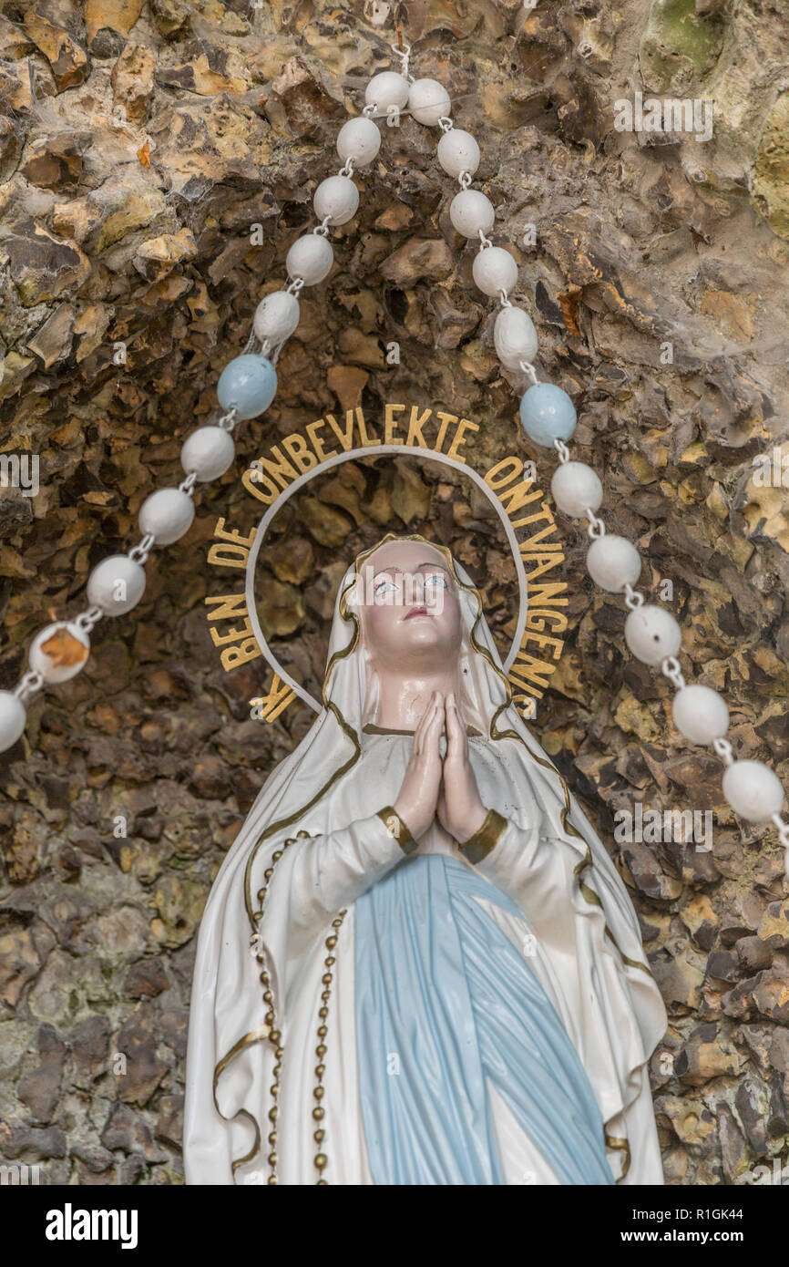 Réplique d'une statue de la Vierge de Lourdes en prière sur un rocher ...