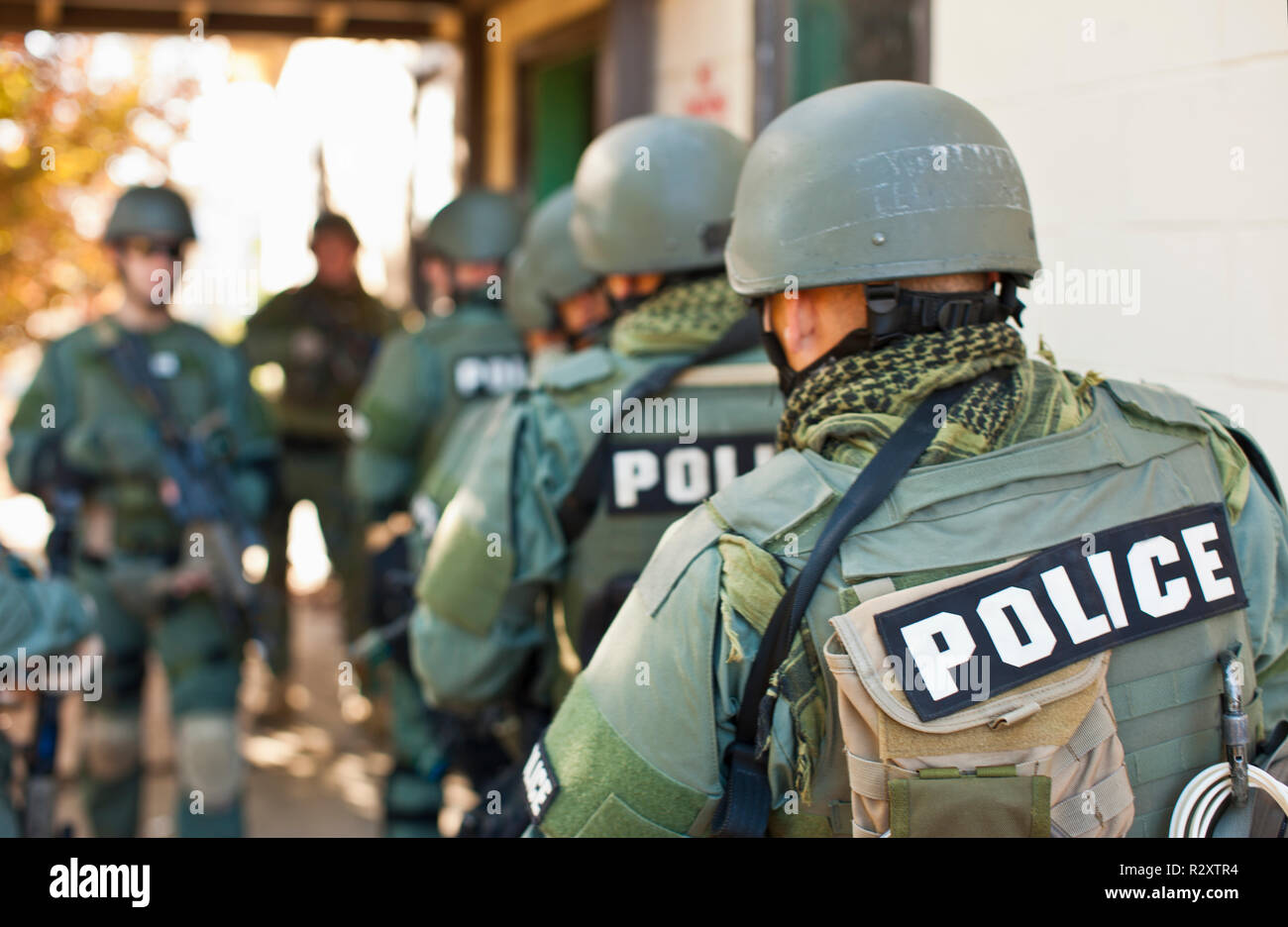 Équipe de la police militaire armé holding guns en marchant ensemble ...