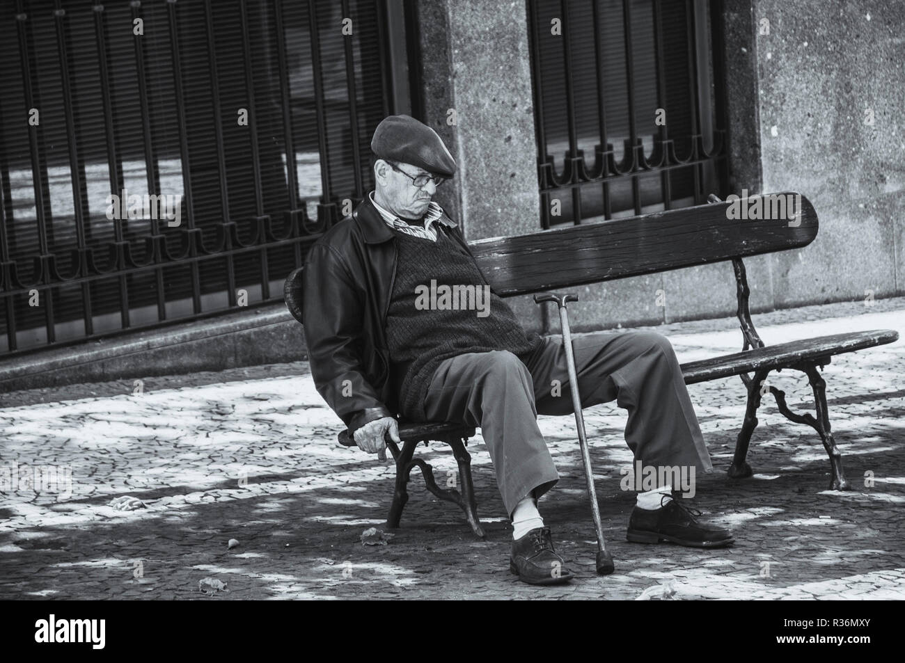 Photo en noir et blanc d'un homme âgé prendre du repos sur une ville ...