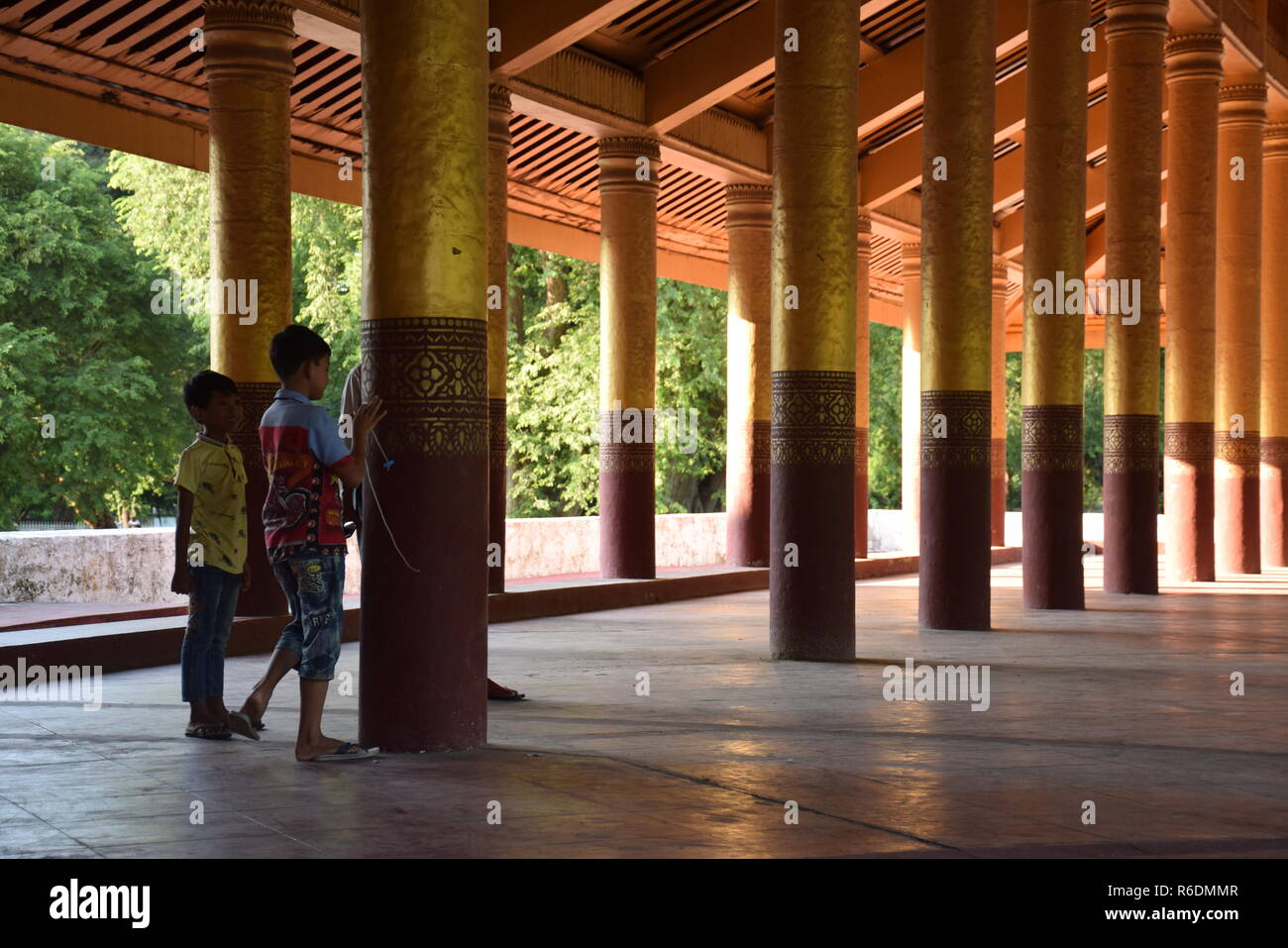 Deux enfants birmans entre les colonnes en bois à l'intérieur du Palais ...