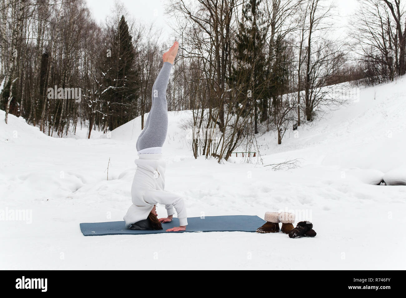 Young woman doing yoga athlétique dans les bois en hiver. Belle fille ...