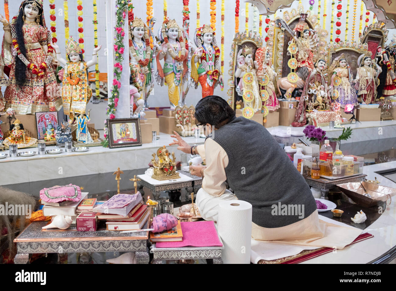 Un prêtre hindou met un bindi sur une petite statue de Ganesh a la ...