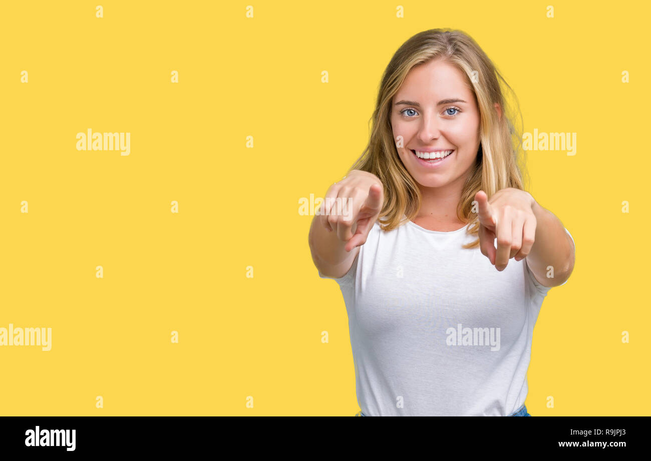 Belle jeune femme portant un t-shirt blanc sur fond isolé pointant vers ...