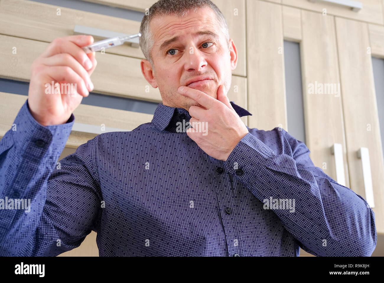 Un homme tenant un thermomètre dans ses mains, la mesure de la ...
