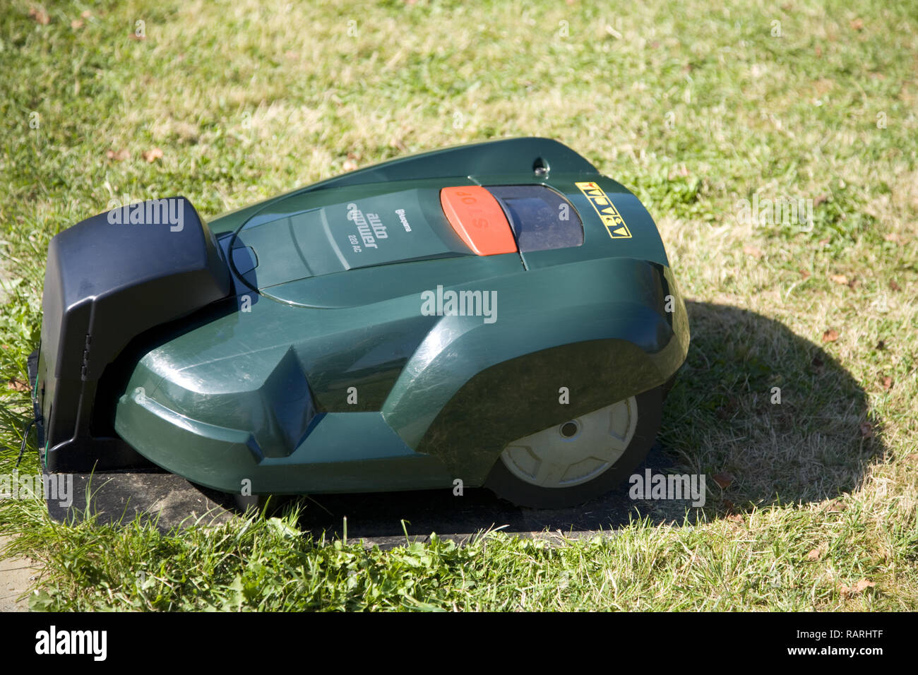 Tondeuse robot automatique vert placé sur sa station de charge, vue d ...