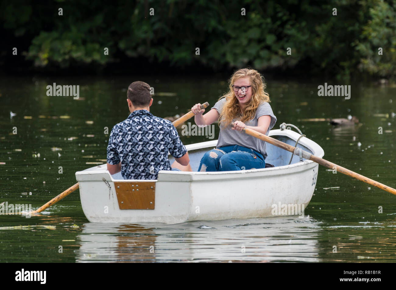 Un jeune couple dans une barque sur un lac de plaisance en été, dans le ...