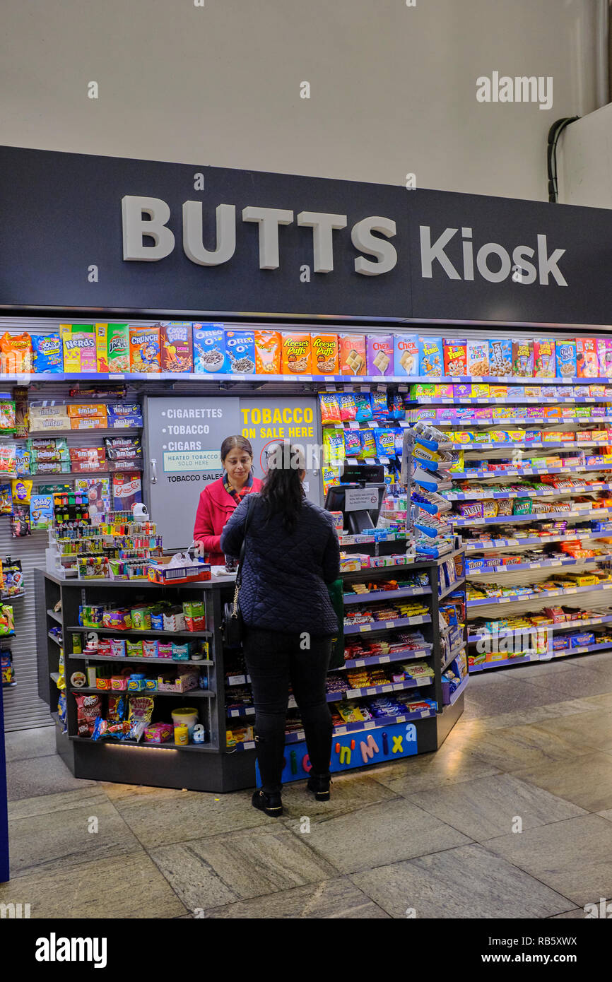 Une femme faisant un achat dans un kiosque qui vend des bonbons et le ...