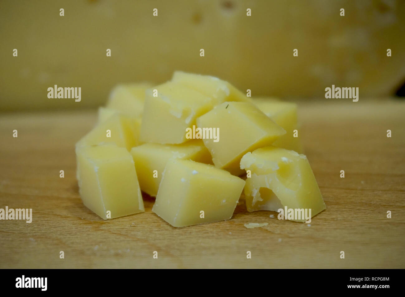Gros plan du Dutch des cubes de fromage avec des trous, sur une planche ...